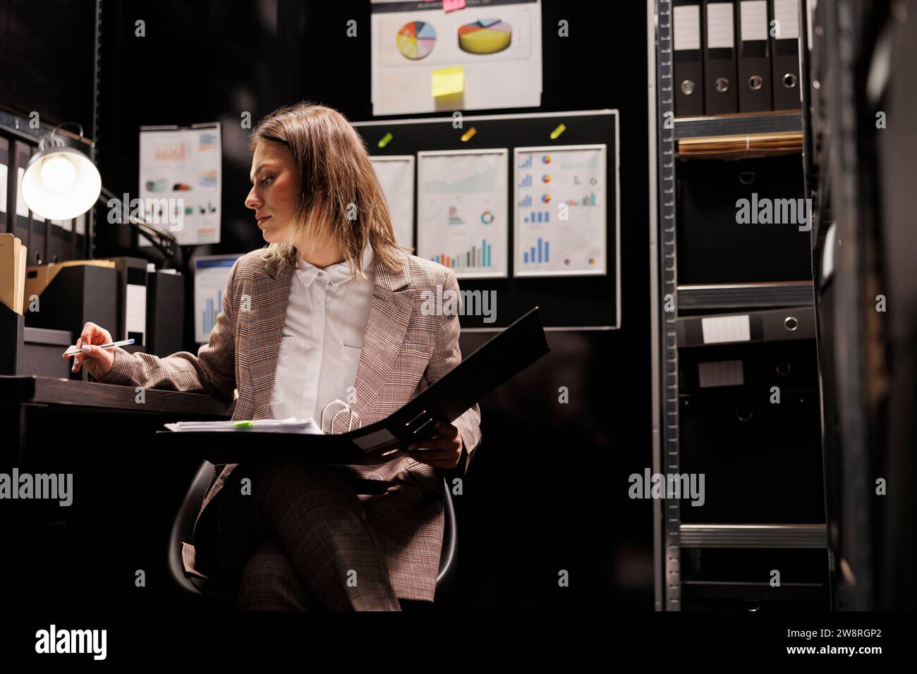 Private detective reading confidential files, working overtime at ...