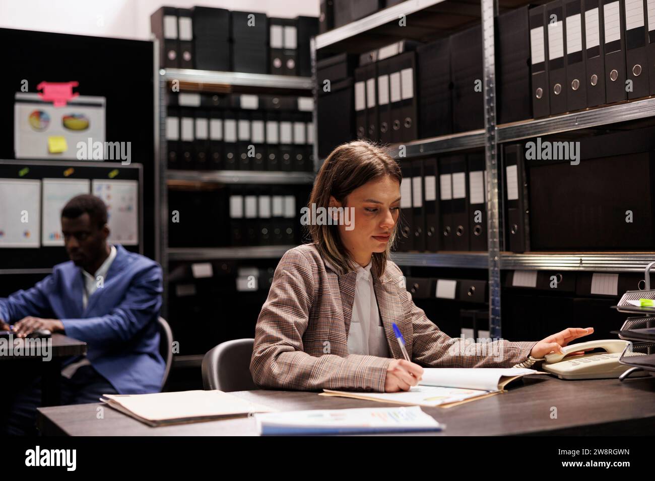 Police officer reading confidential report, working late at night at ...