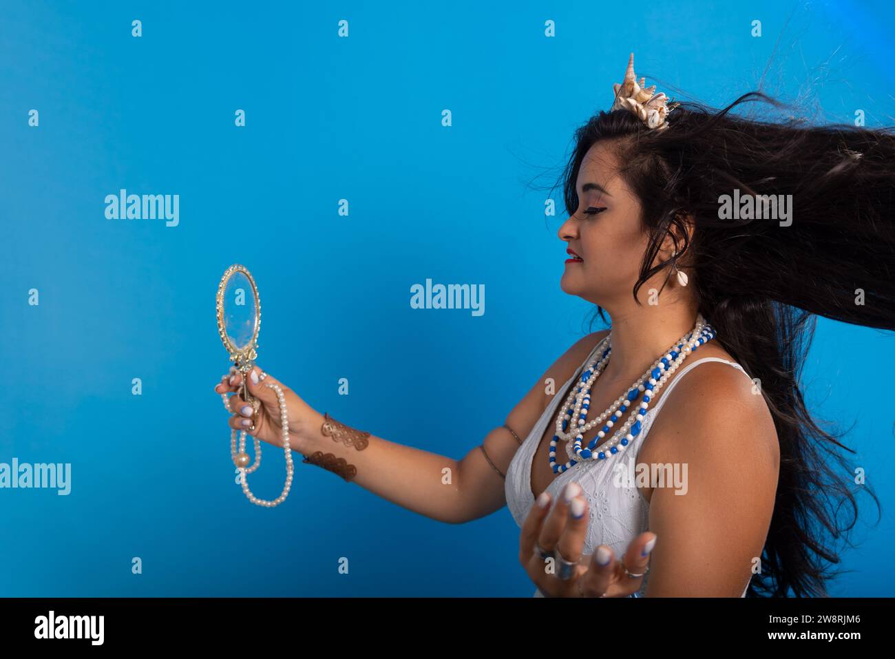 Portrait of beautiful black-haired woman wearing white outfit, holding ...