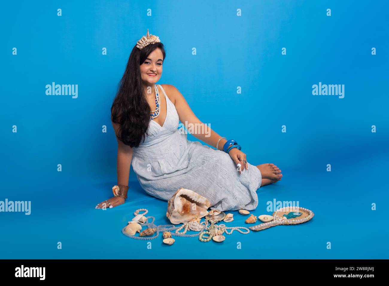 Portrait of beautiful black-haired woman wearing white clothes, sitting ...