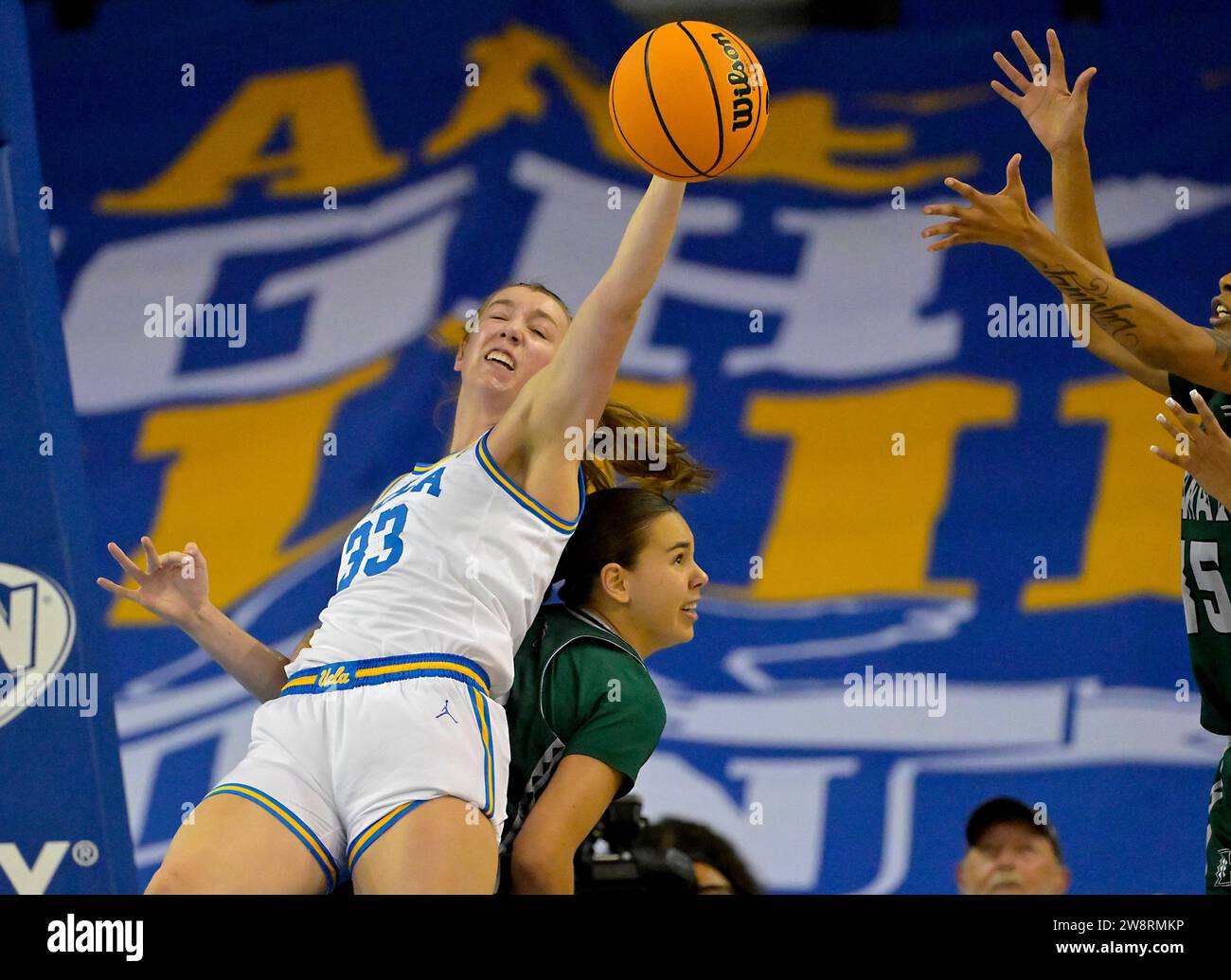 UCLA forward Amanda Muse, left, reaches over Hawaii guard Jade Peacock ...