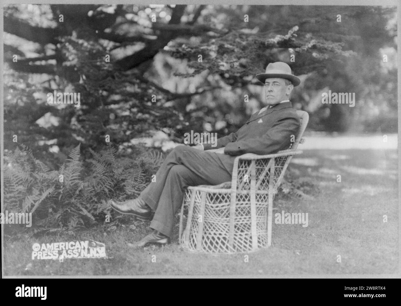 Woodrow Wilson, full, seated in wicker chair on lawn of Prospect, his ...