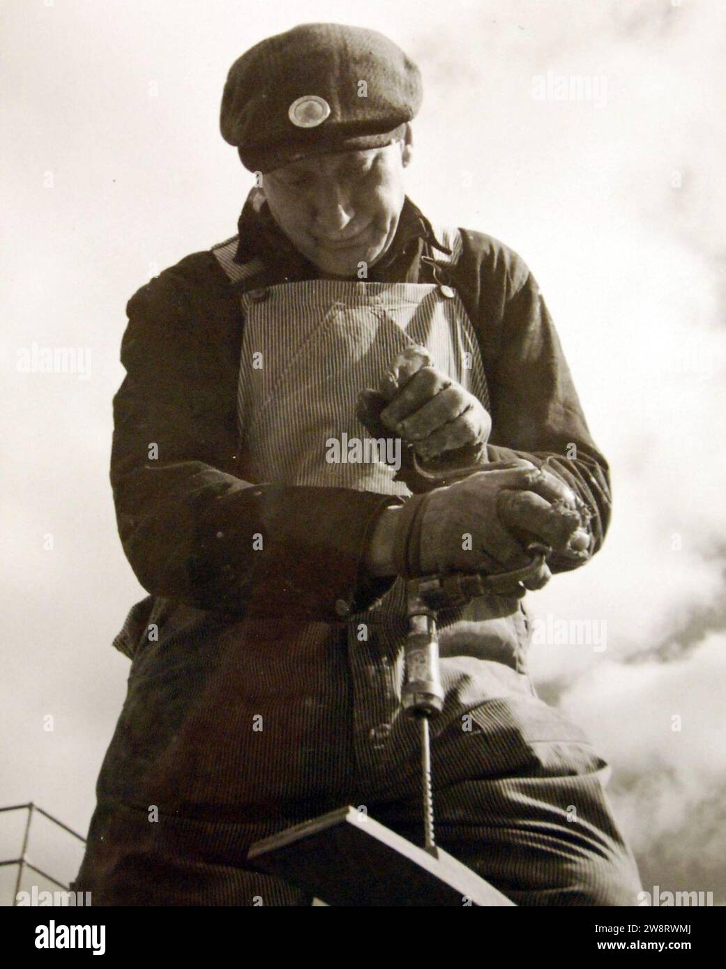 Worker uses tools to fit coamings to machine-gun wings on submarine ...