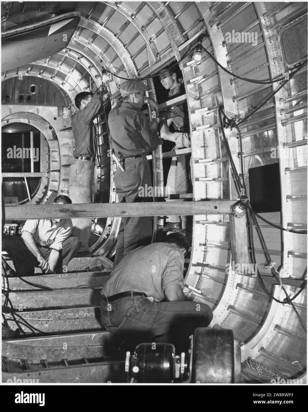 Workers assembling the bottom of an aircraft Stock Photo - Alamy