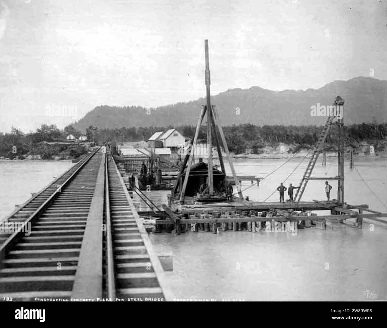 Workers constructing concrete piers for a steel bridge across the ...