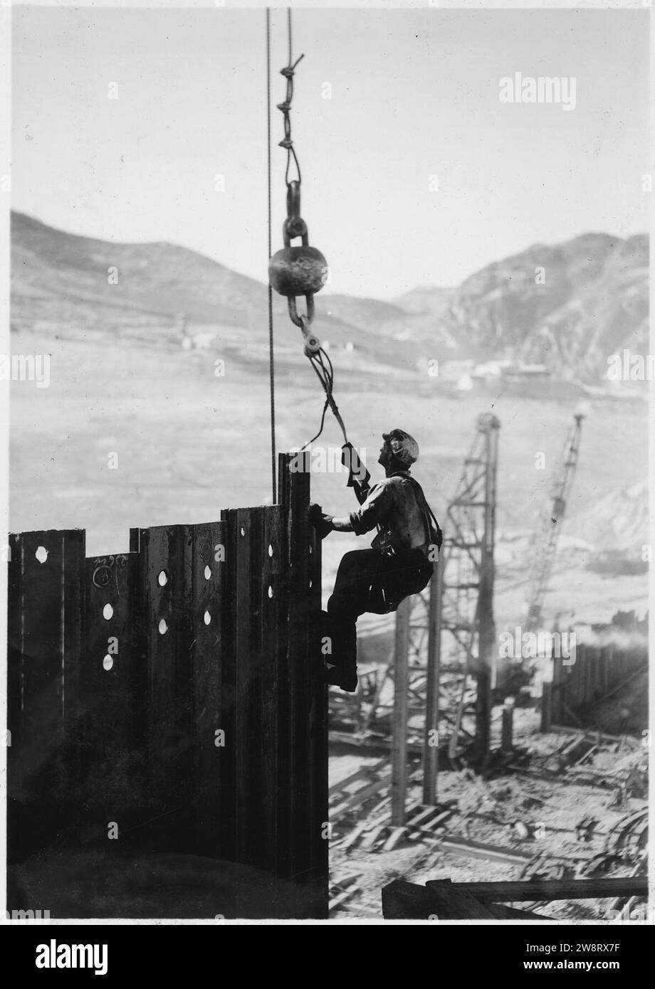 Workman placing steel piling in cofferdam cell Stock Photo - Alamy