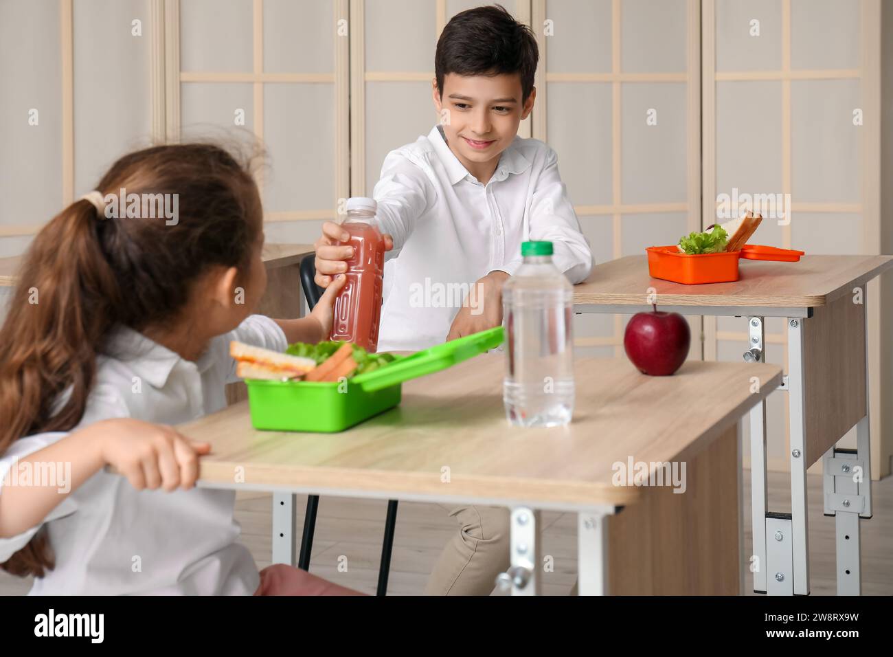 Little children eating lunch in classroom Stock Photo - Alamy