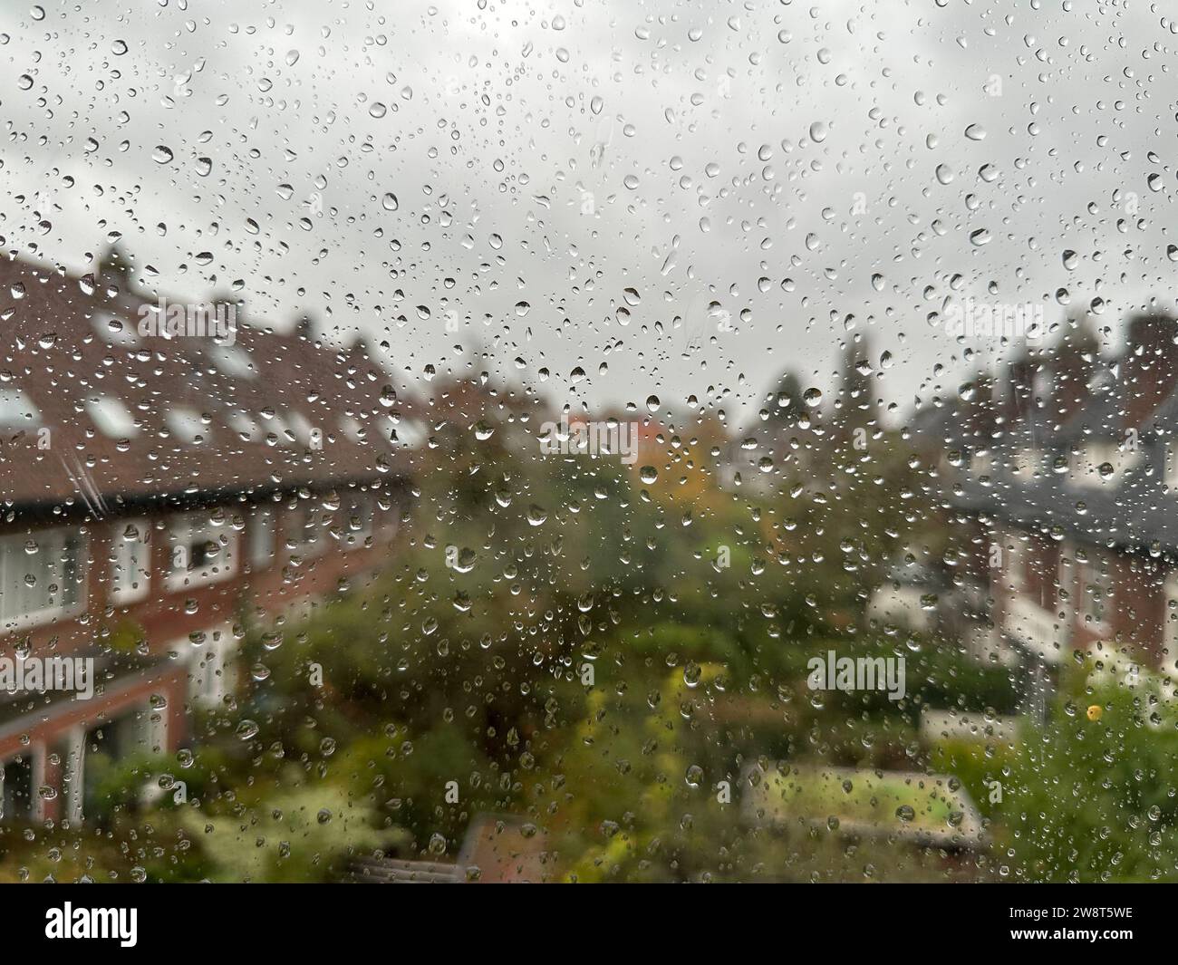 View on city street through window with water droplets on rainy day ...