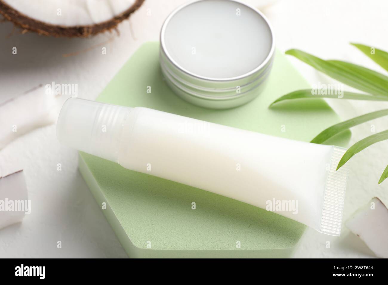 Lip balms and leaves on white background Stock Photo - Alamy