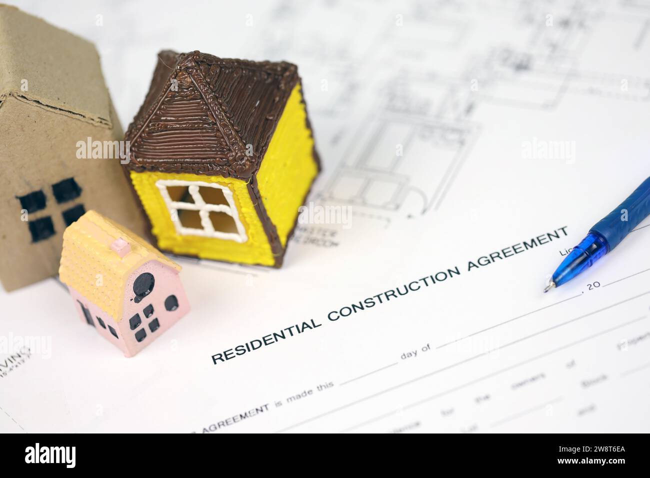 Residential construction agreement ready to sign with small toy houses ...