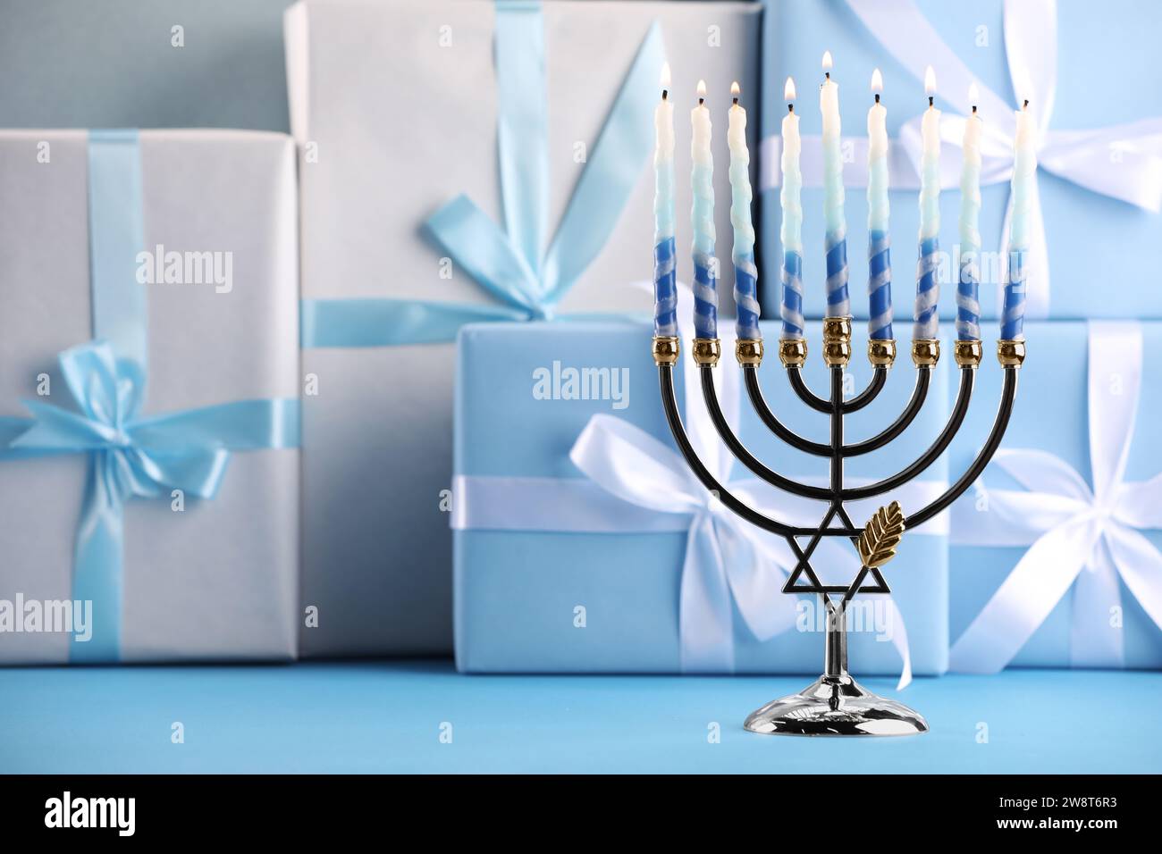 Hanukkah celebration. Menorah with burning candles and gift boxes on ...