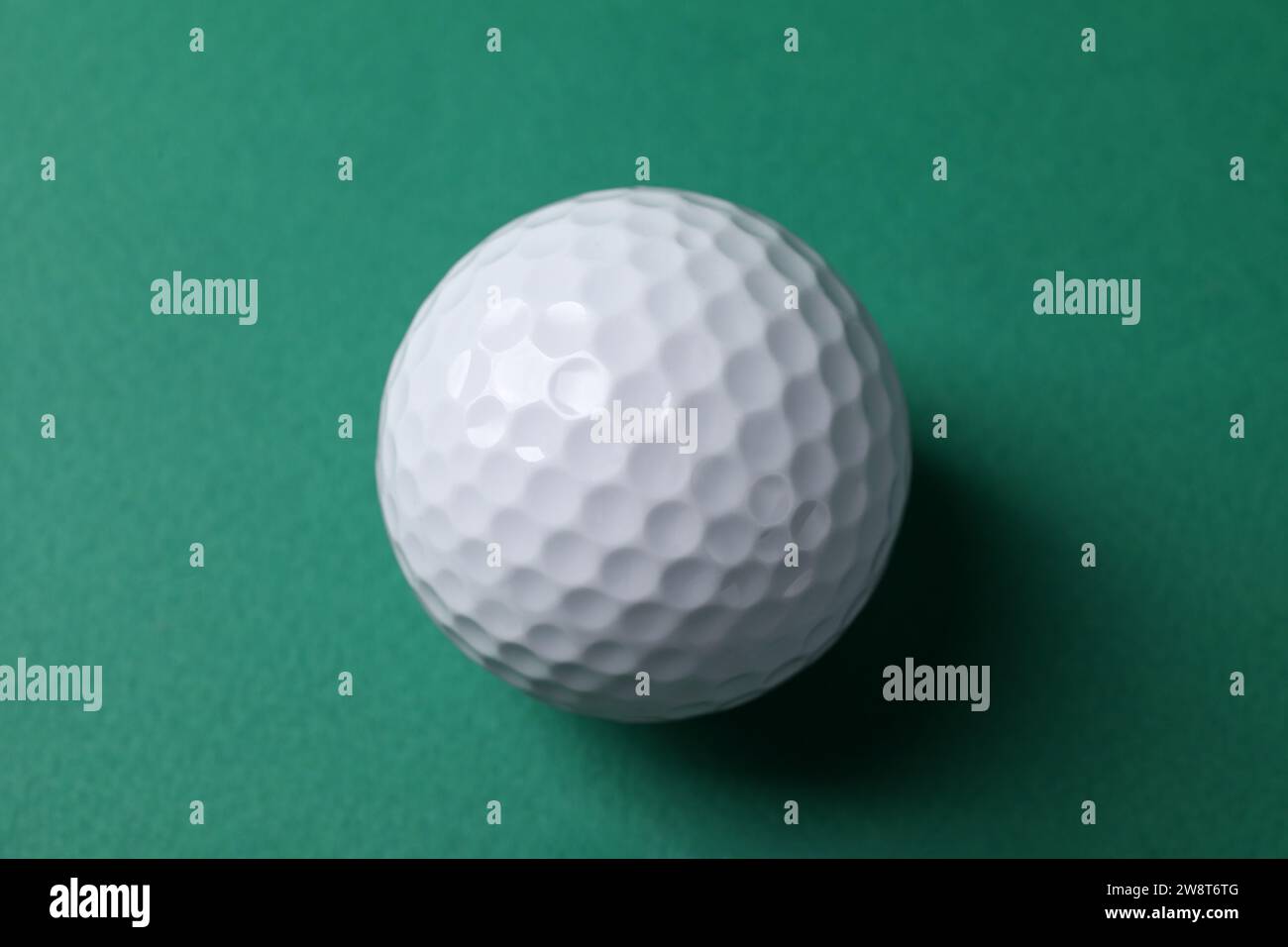 One golf ball on green background, top view Stock Photo - Alamy
