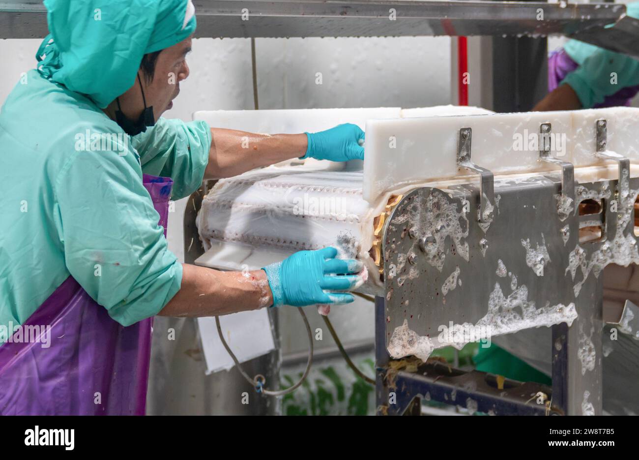 Worker use clean water to wash conveyor belts to remove dirt in ...