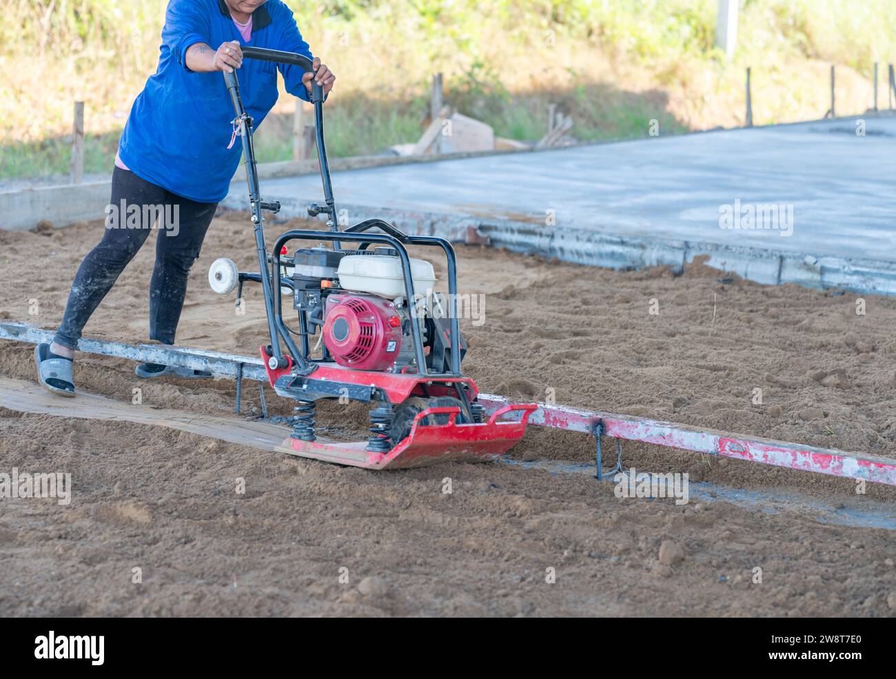 Vibrating soil compactor used to compact soil in preparation for ...