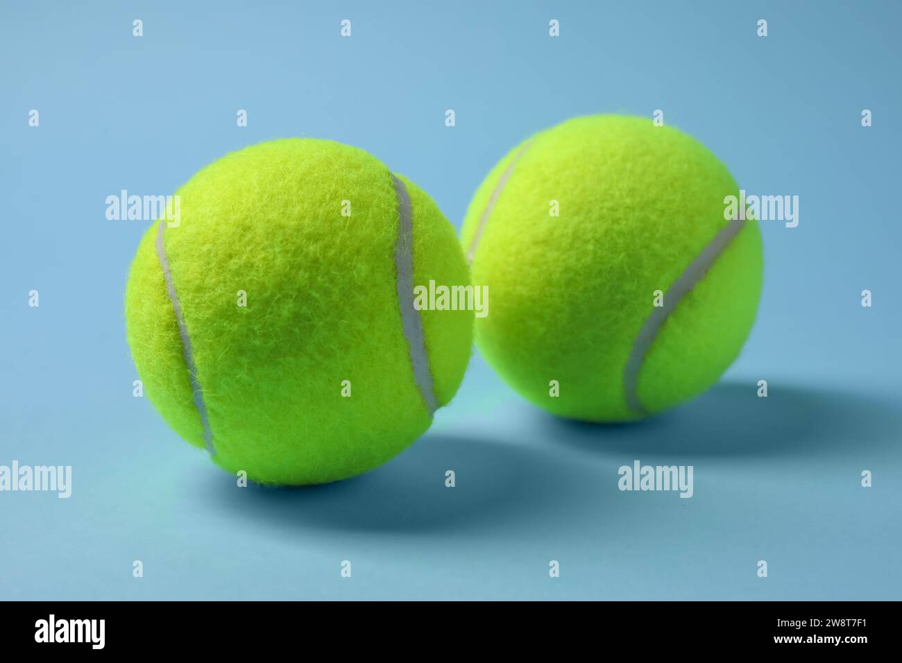 Two tennis balls on light blue background, closeup Stock Photo - Alamy