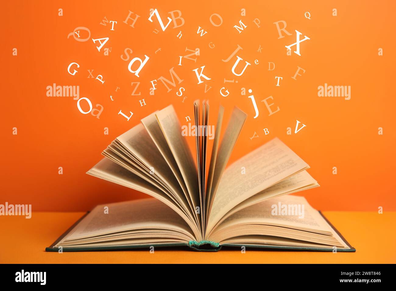 Open book with letters flying out of it on orange background Stock ...