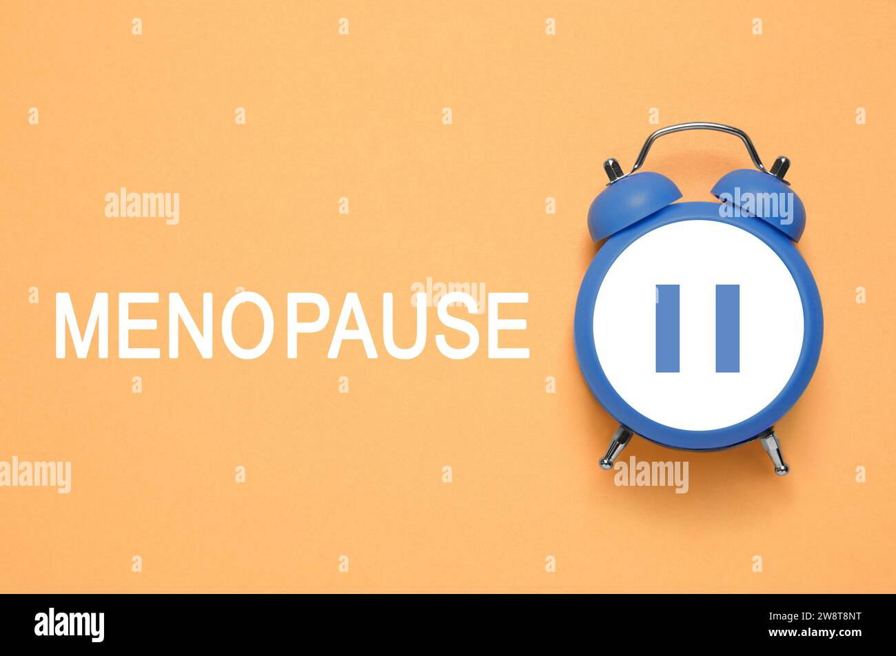 Menopause word and alarm clock with pause symbol on orange background ...