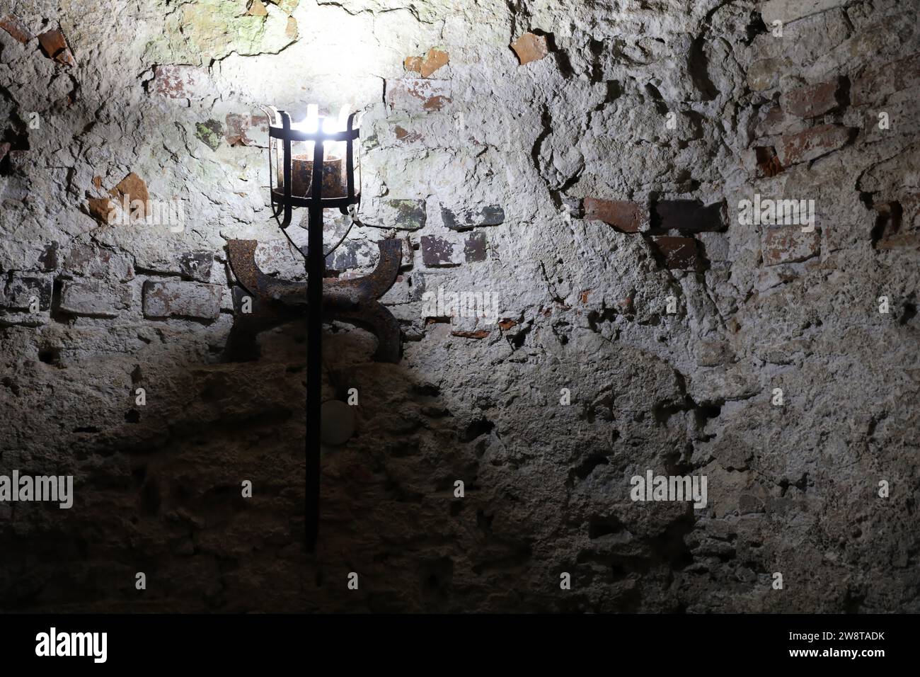 Lighted medieval castle torch hanging on a stone wall, vintage objects ...