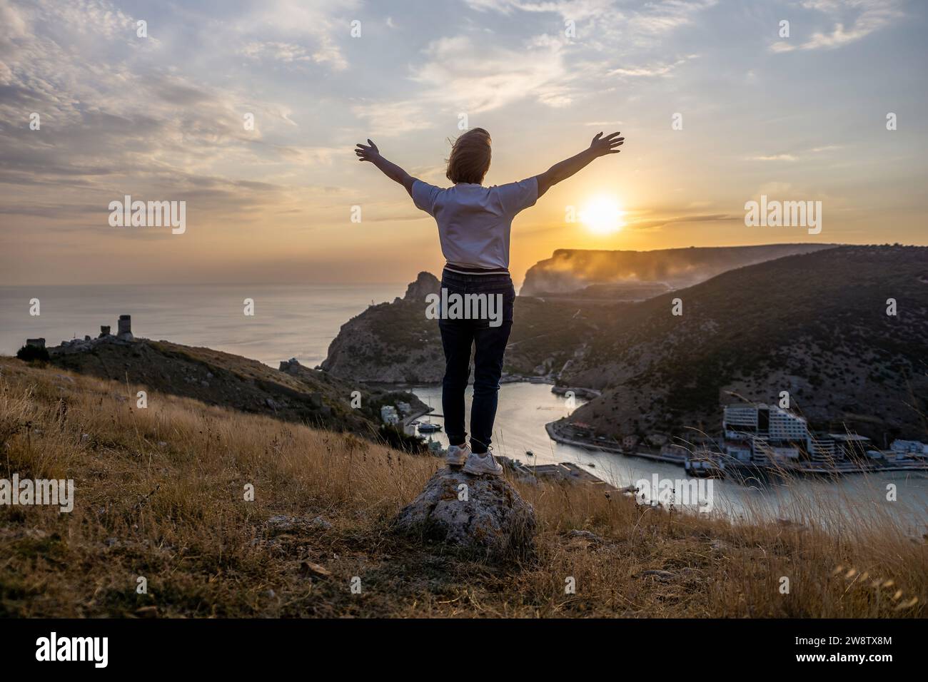 Happy woman on sunset in mountains. Woman standing with her back on the ...