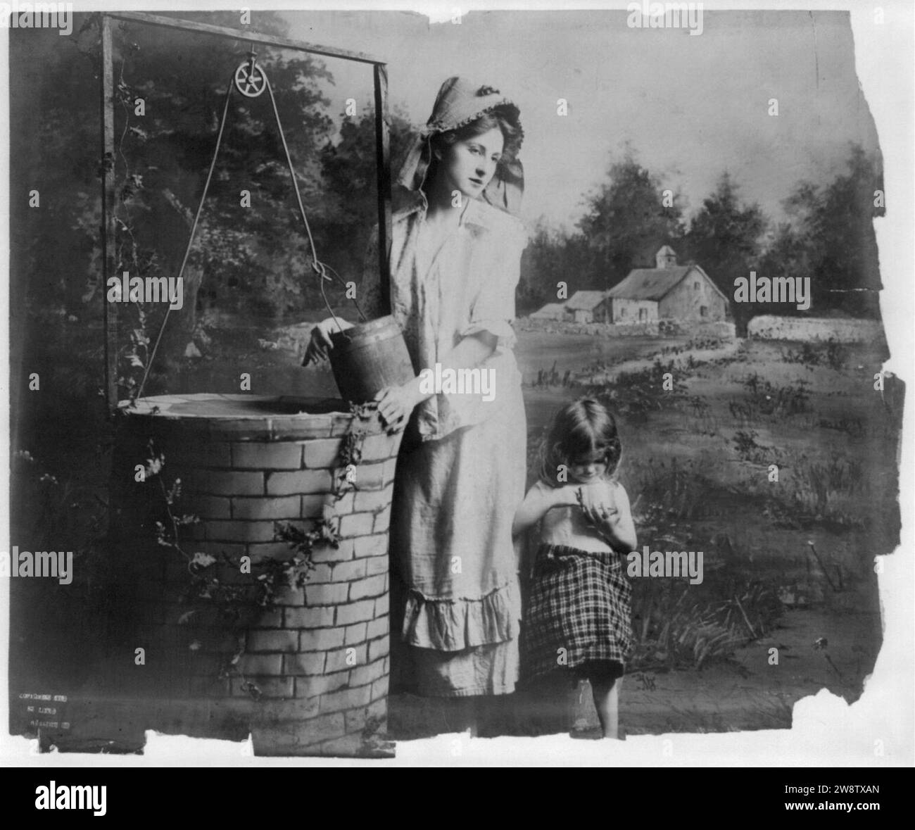 Young woman modeling- Full lgth., standing at well, with little girl ...