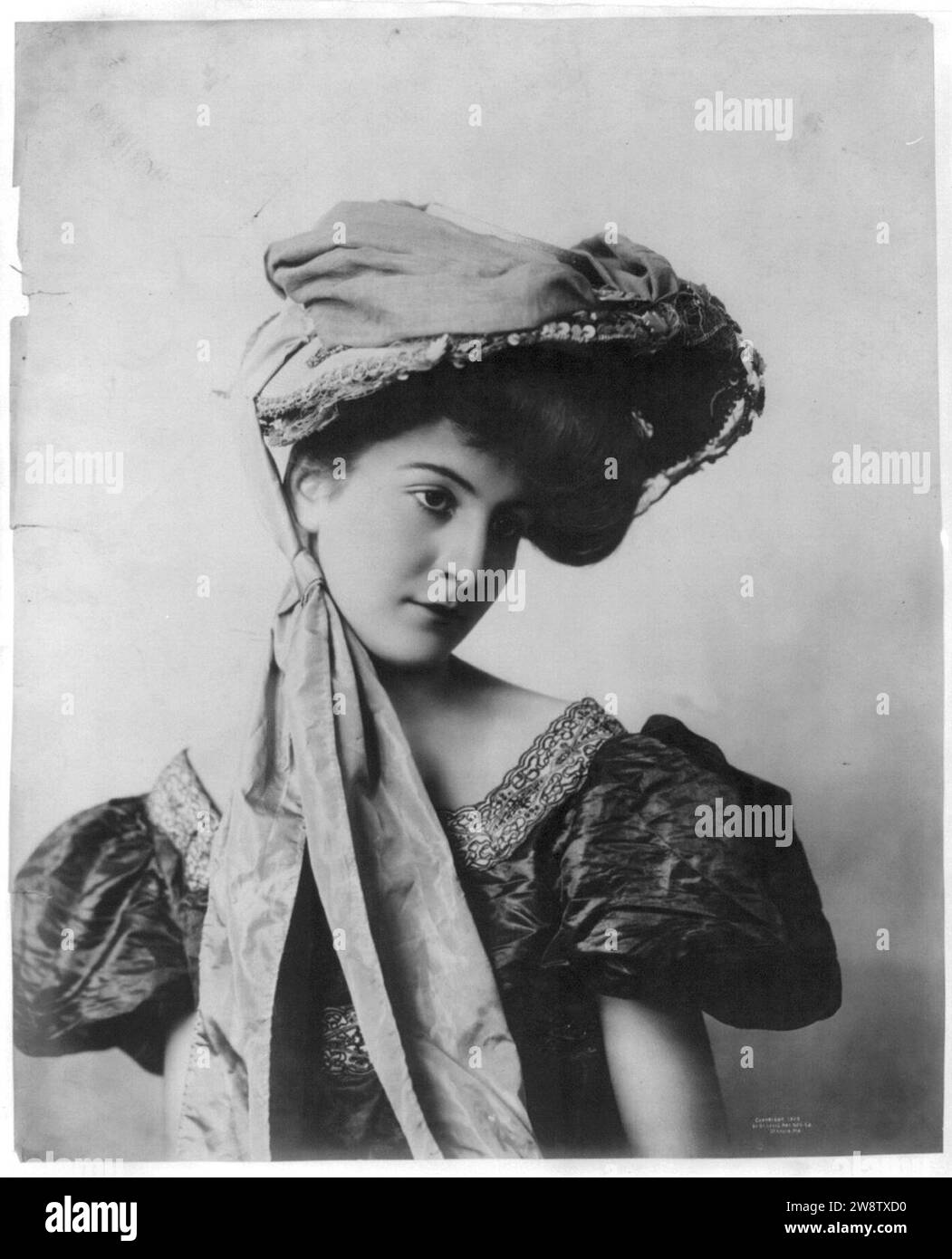 Young woman modeling- Half lgth., 2 long pieces of material draped from ...