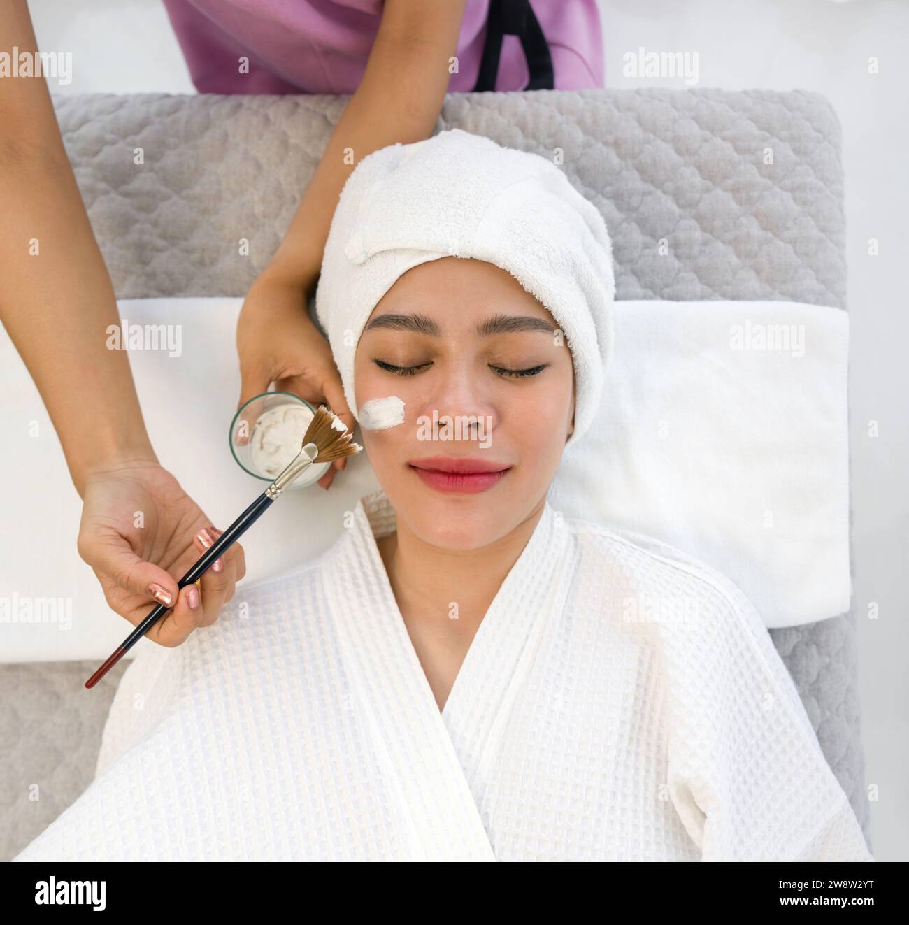 A woman is lying down, relaxed and serene, while receiving a soothing ...