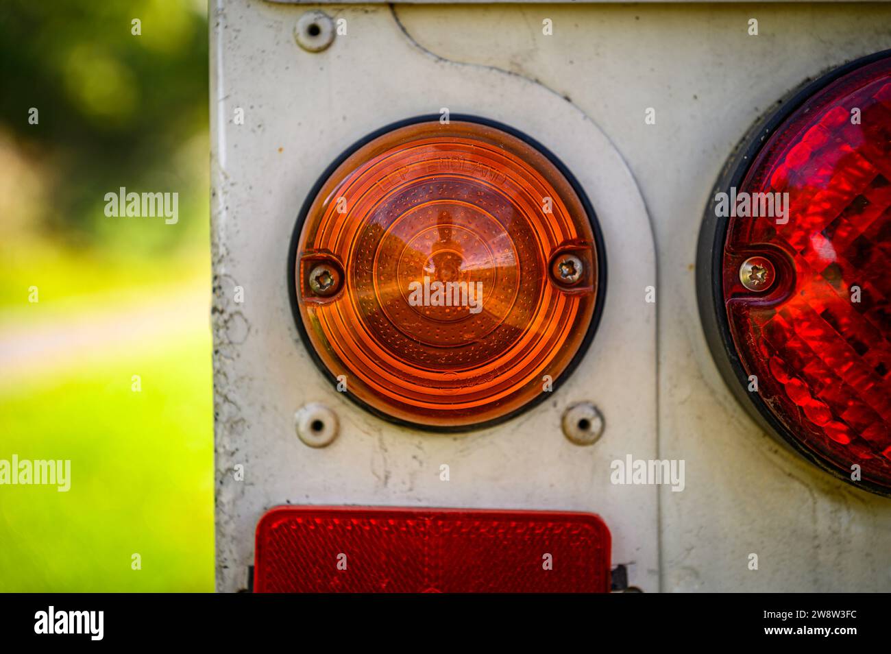 "Close-up of the orange turn signal and the rear fog light of the left ...