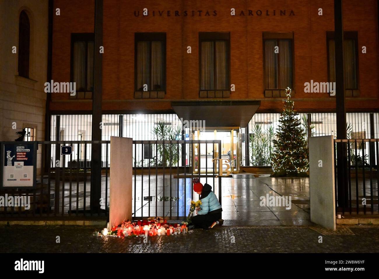 A mourner lays a candle light outside the building of Philosophical ...