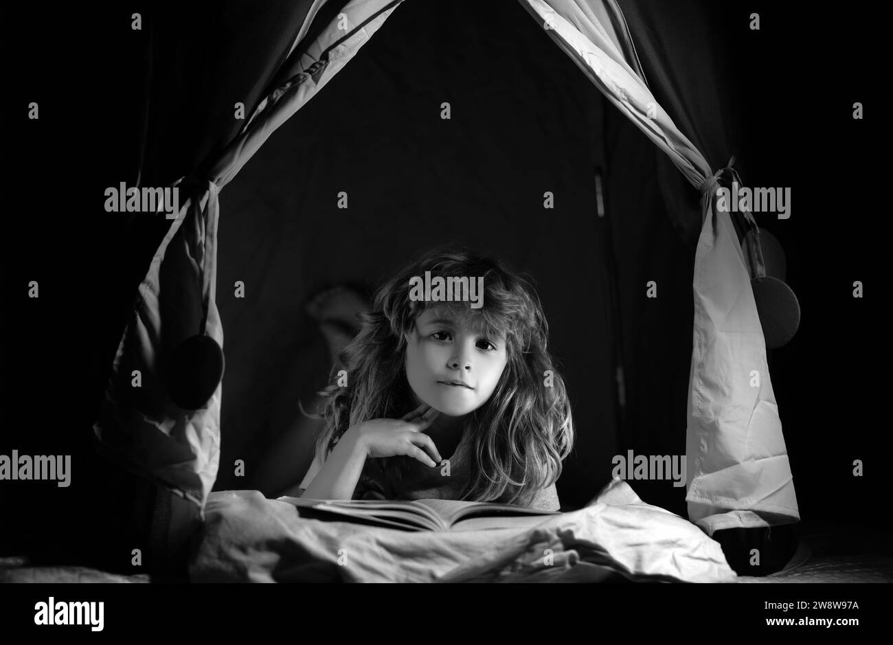 Kid boy in kids tent reading books. Towards knowledge. Boy with book ...