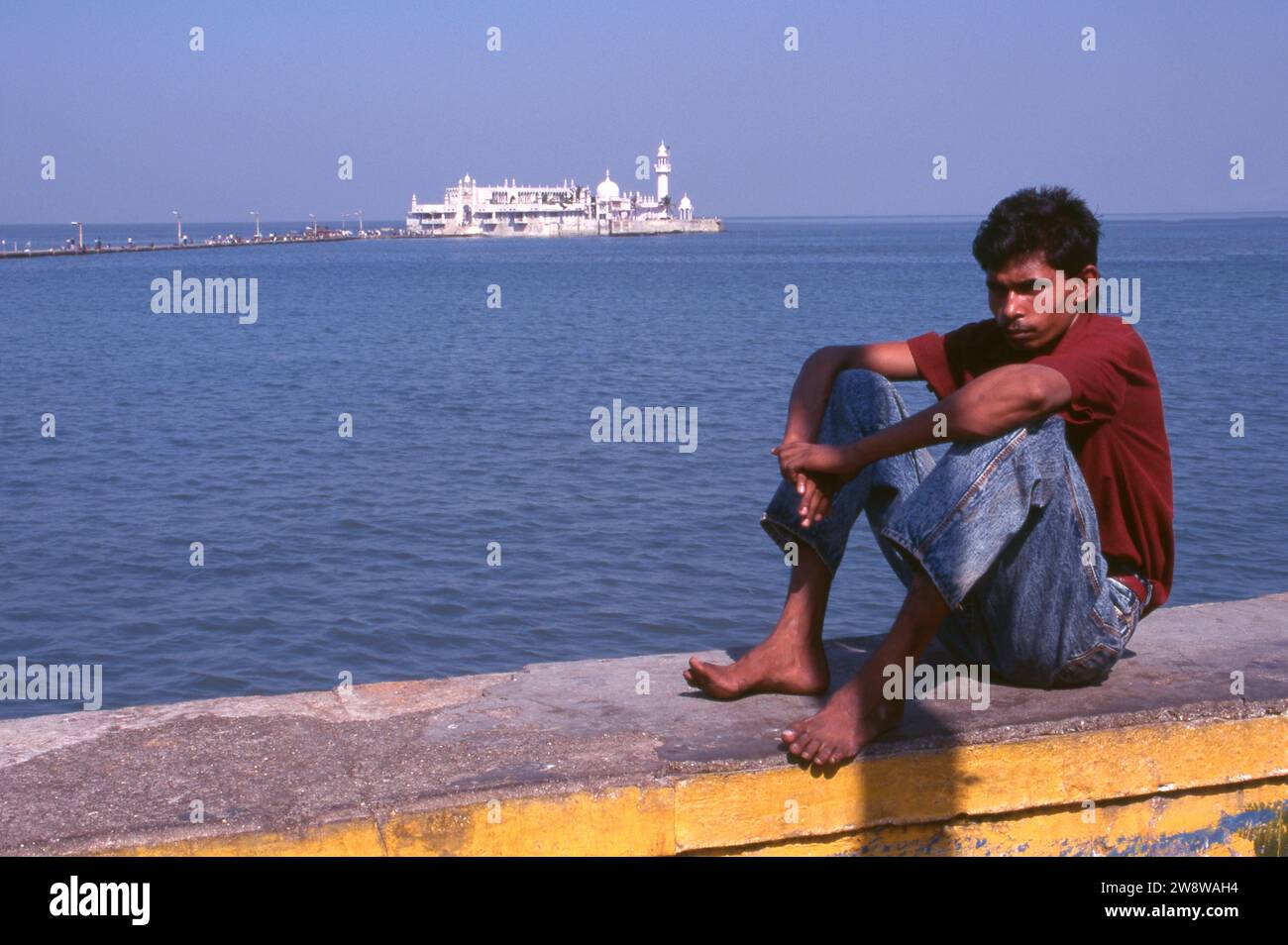 India: A man takes a rest on the seawall in front of Haji Ali Mosque ...