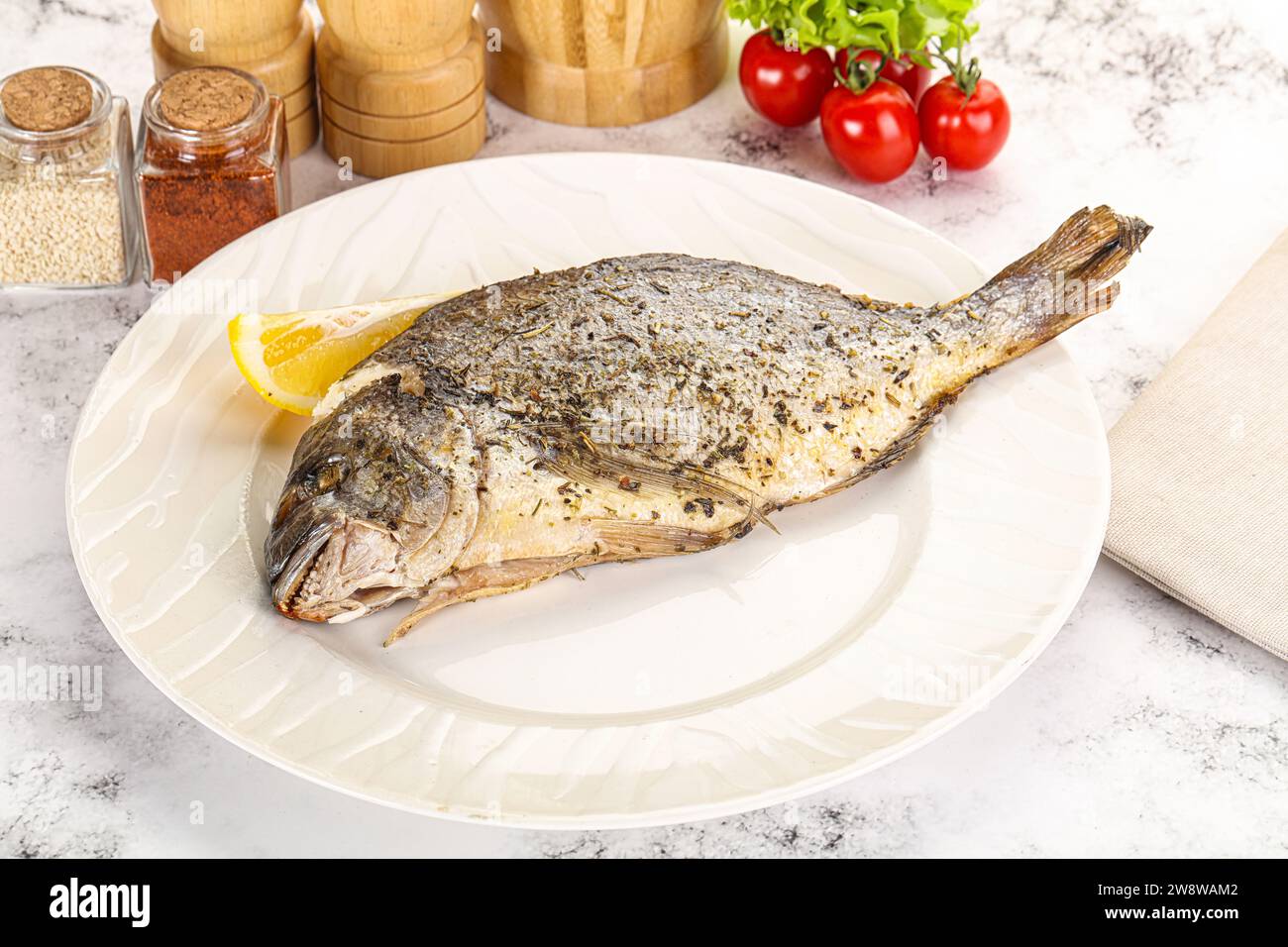 Baked Dorado fish served lemon slice Stock Photo - Alamy