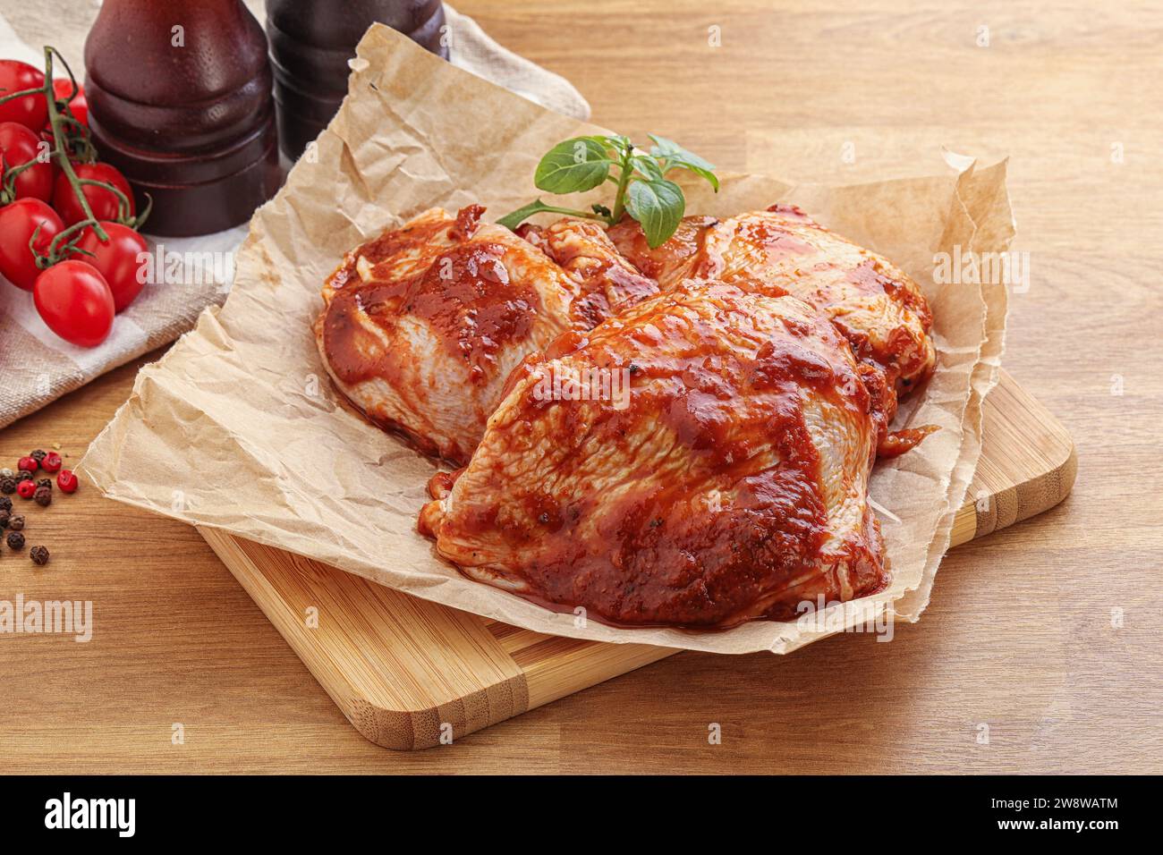 Marinated chicken leg thighs in tomato sauce Stock Photo - Alamy