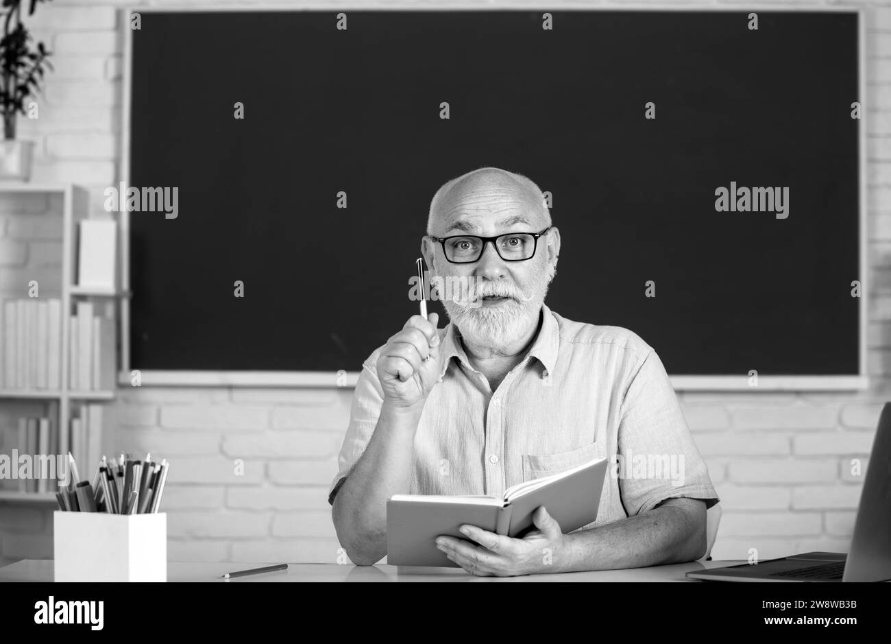 Portrait of senior teacher teaching line of high school students with ...