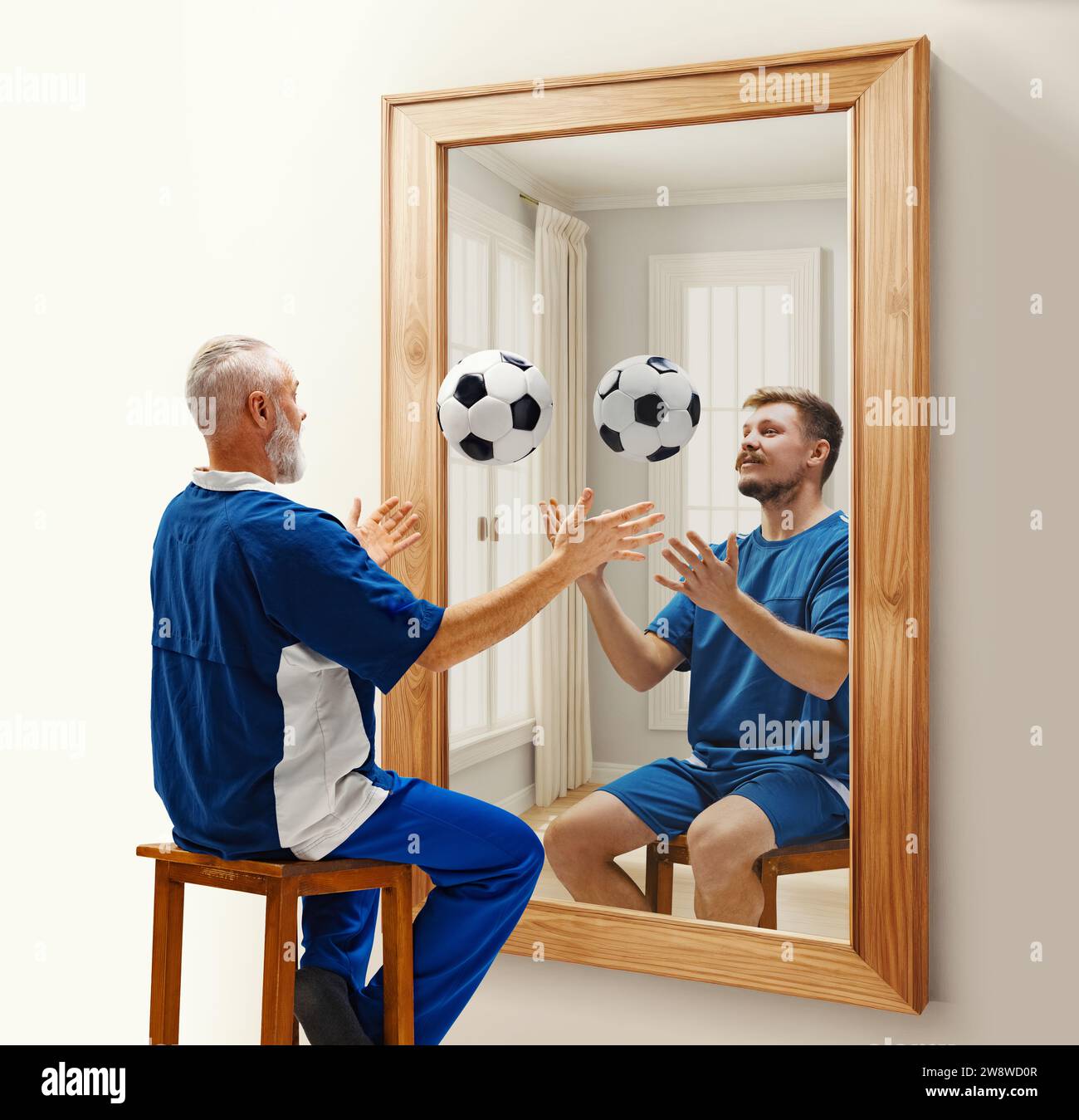 Senior man in uniform sitting with football ball near mirror with ...