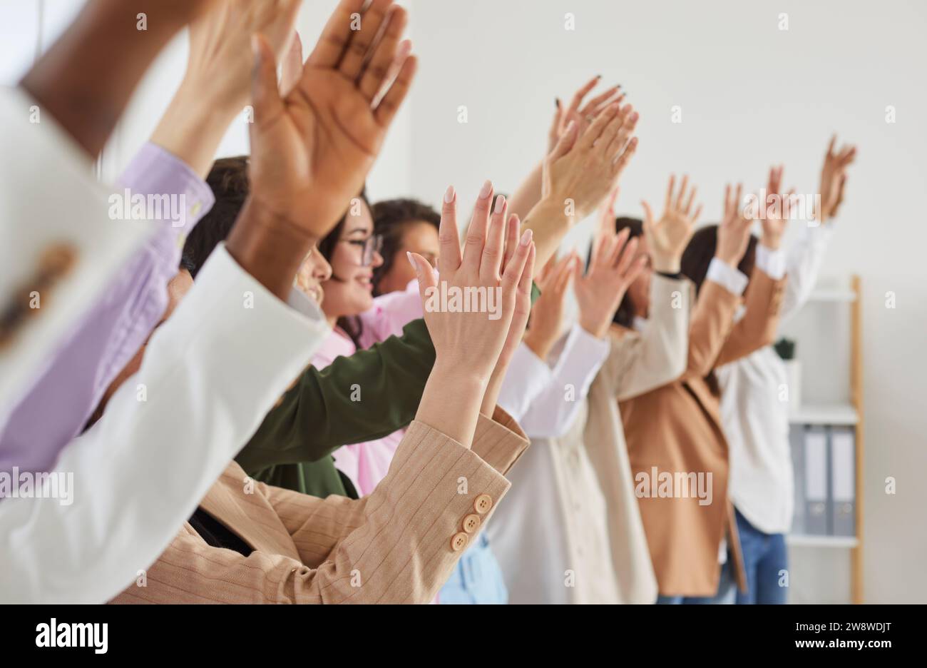 Happy female audience raising their hands to ask questions at a ...