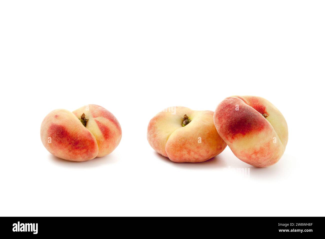 Three ripe chinese flat peach fruits or saturn peaches with soft shadow ...