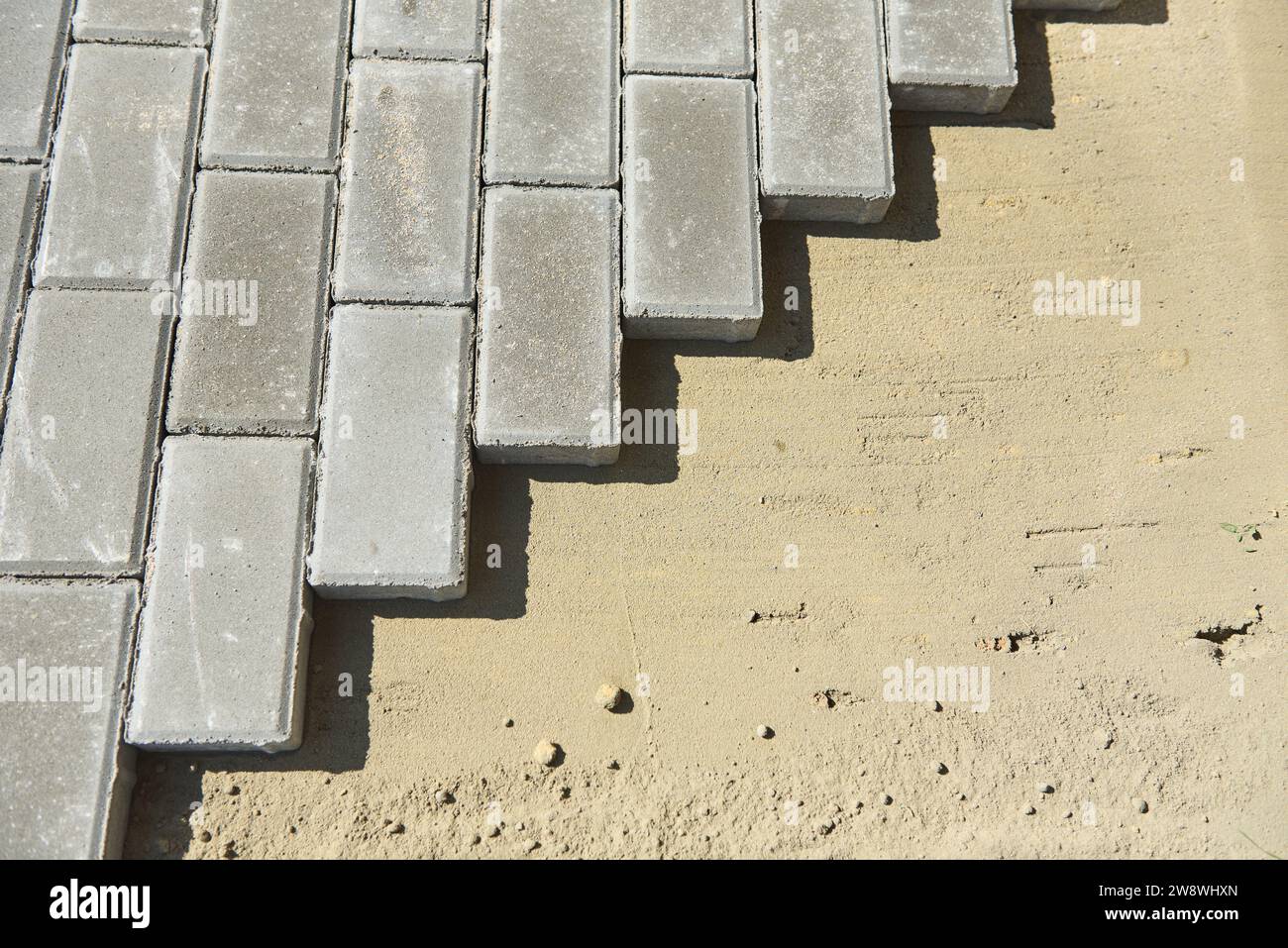 Paving slabs on sand during the construction process Stock Photo - Alamy