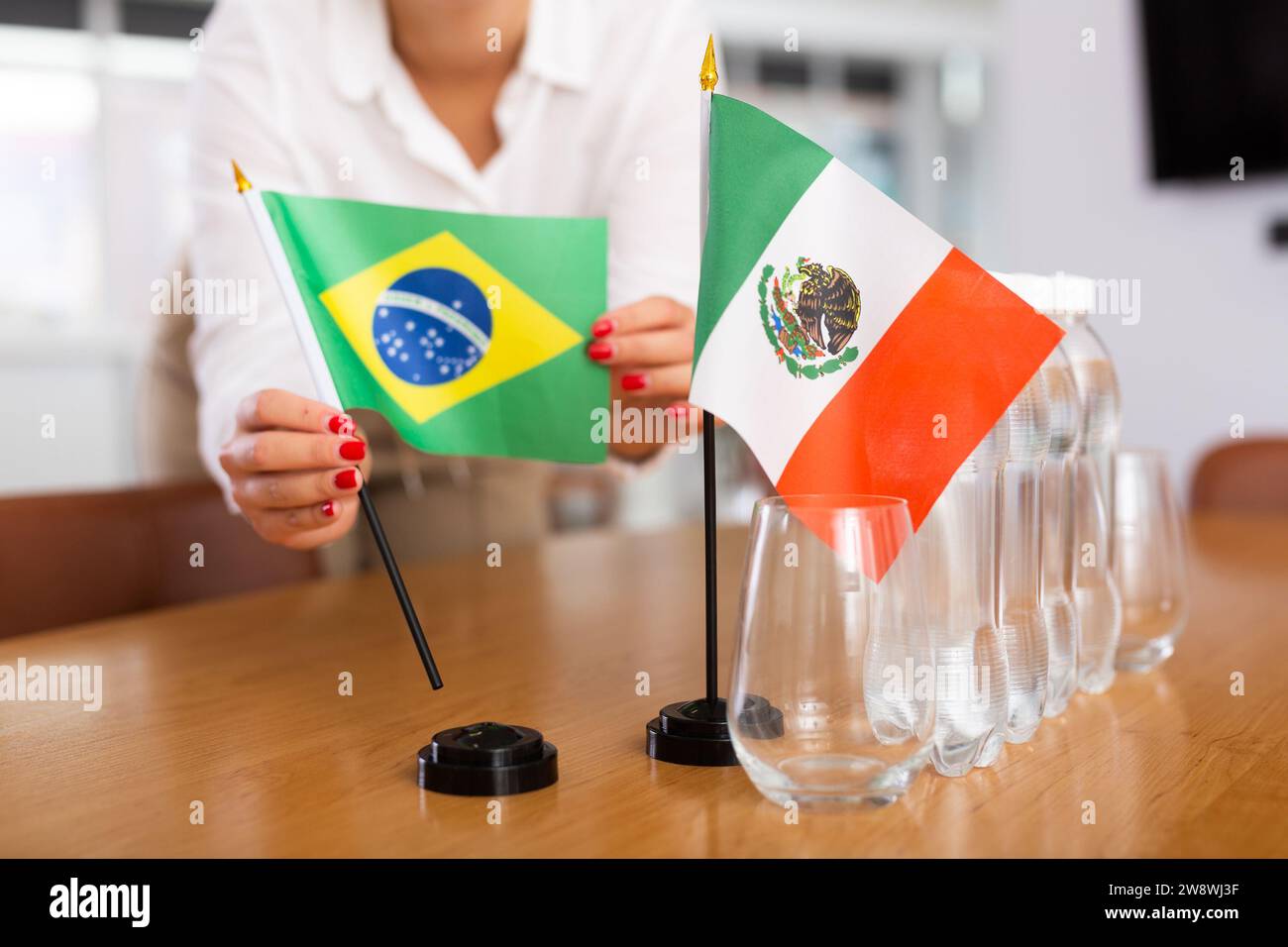 Unrecognizable girl sets midget flags of Mexico and Brazil before ...