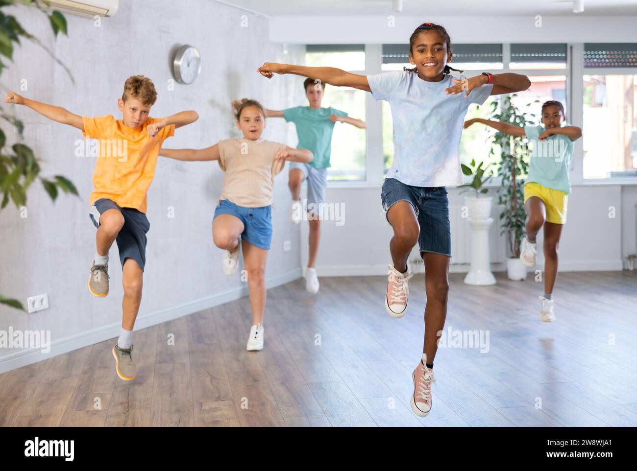 Cheerful african american tween boy dancing lezginka with group of ...