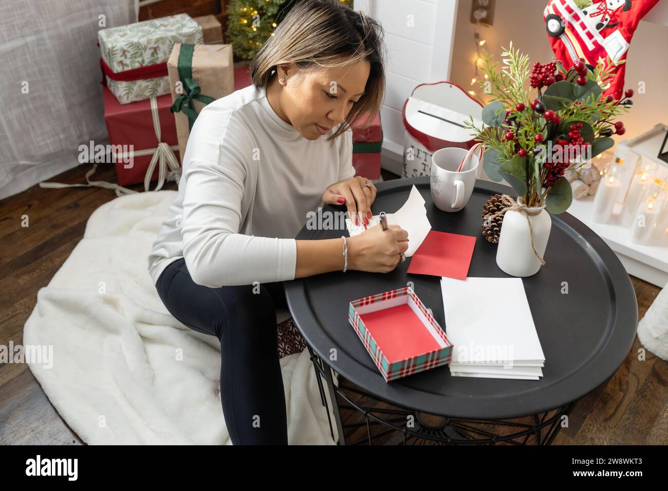 Woman writing out her christmas cards, sending mail Stock Photo - Alamy