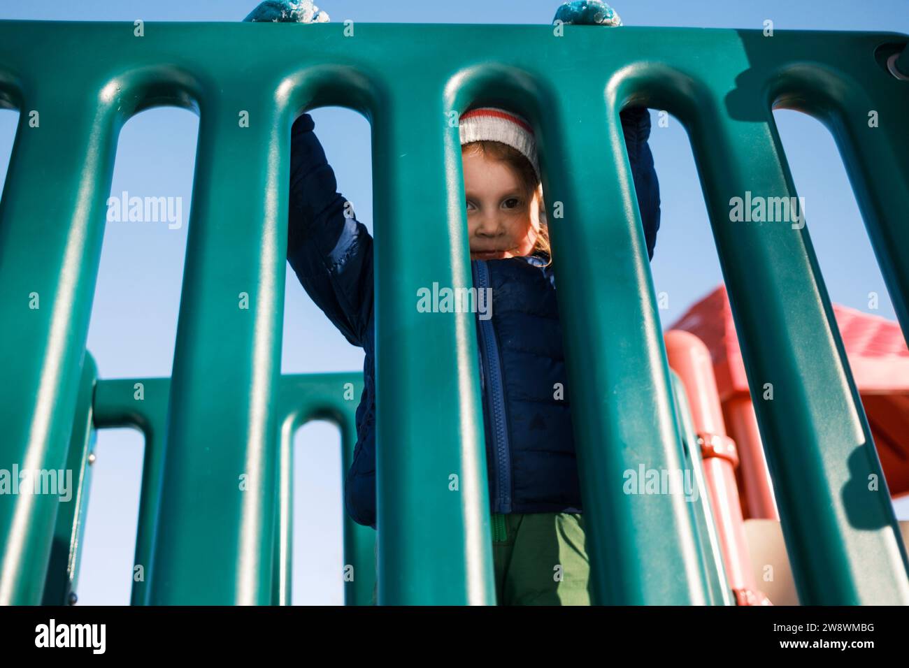 Happy child wearing warm clothing at a playground Stock Photo - Alamy