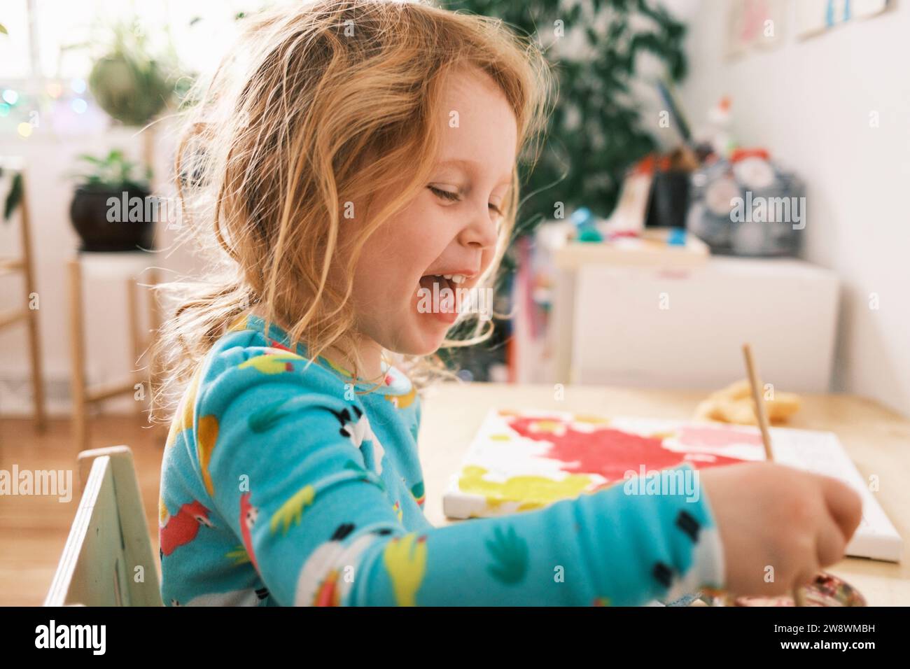 Happy child painting and laughing Stock Photo - Alamy