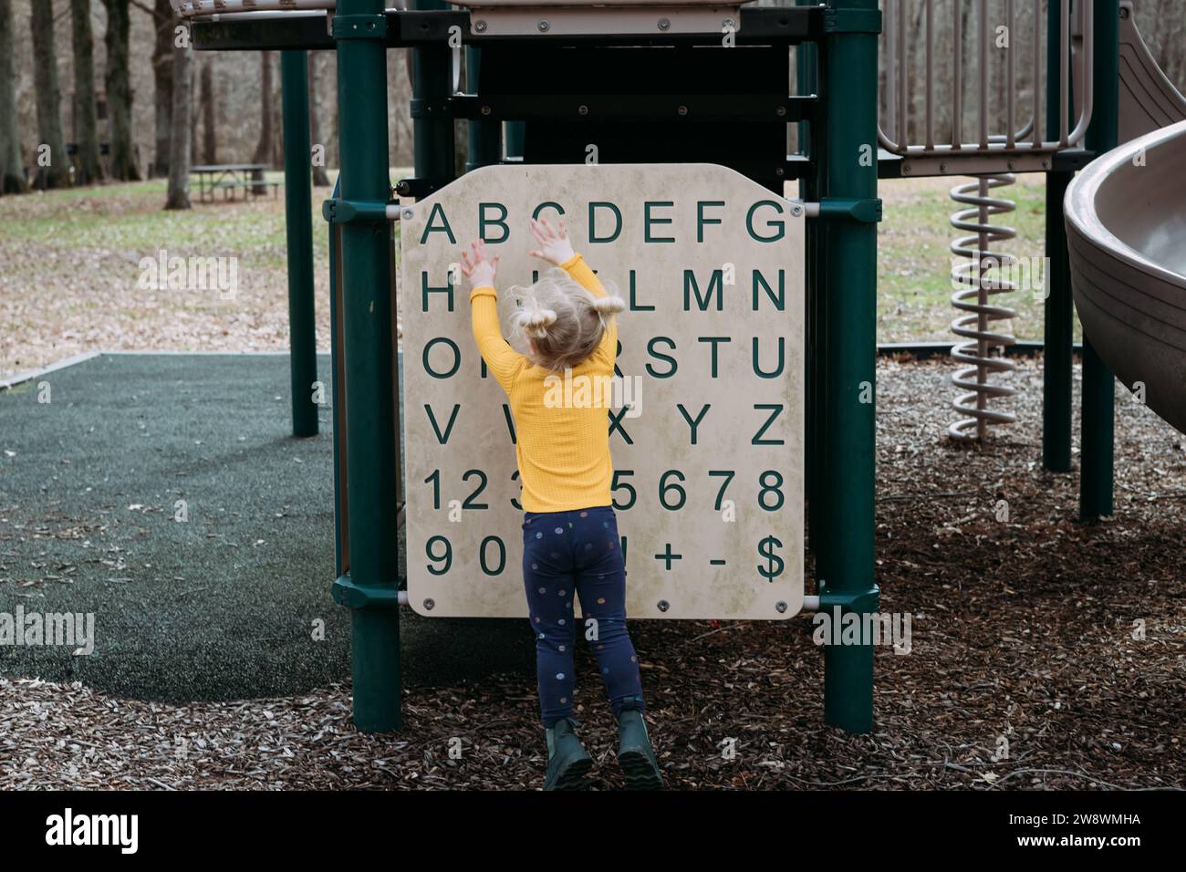 Young child playing with alphabet structure on park playground Stock ...