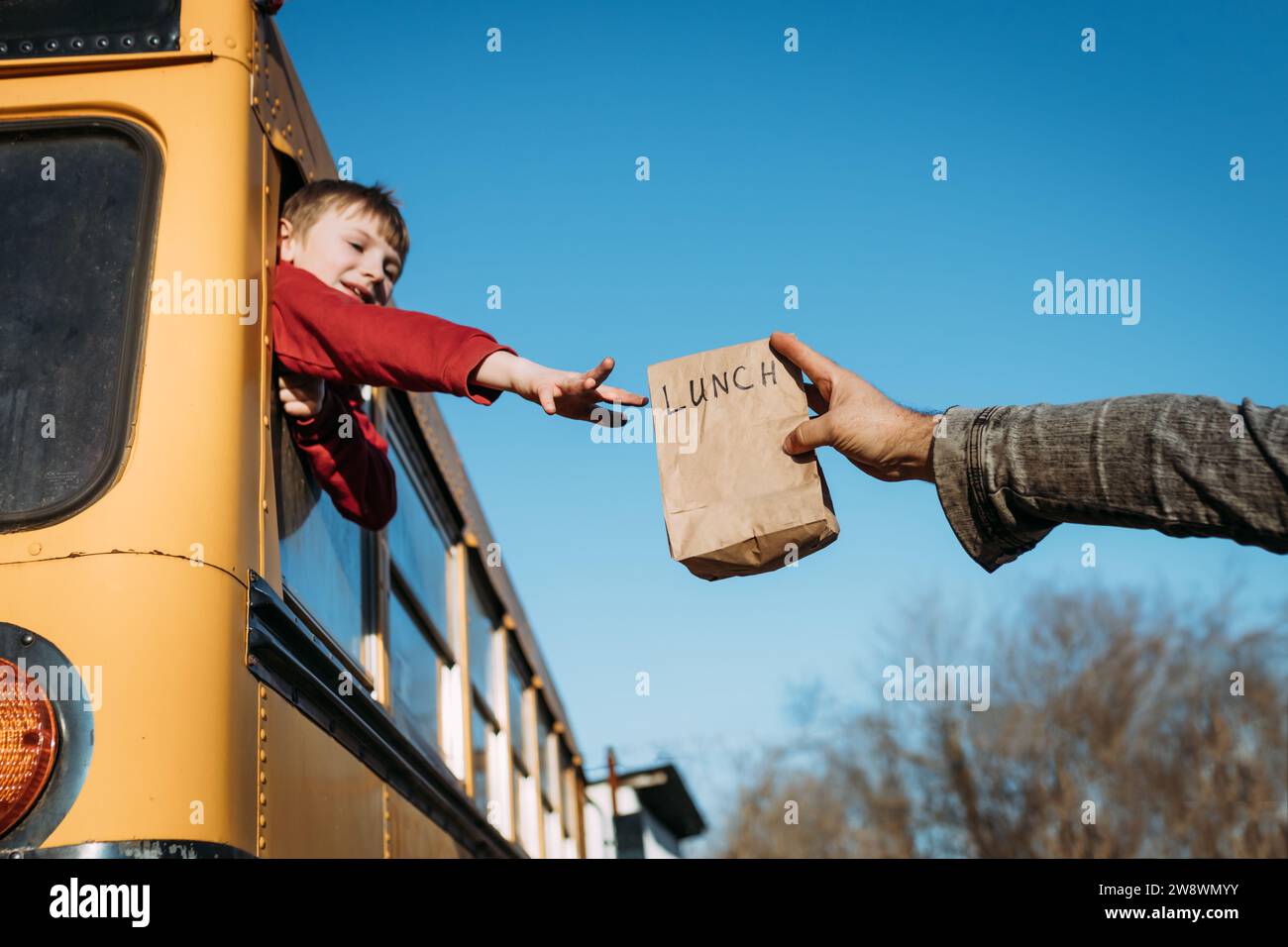 Child reaching for lunch bag from school bus Stock Photo - Alamy