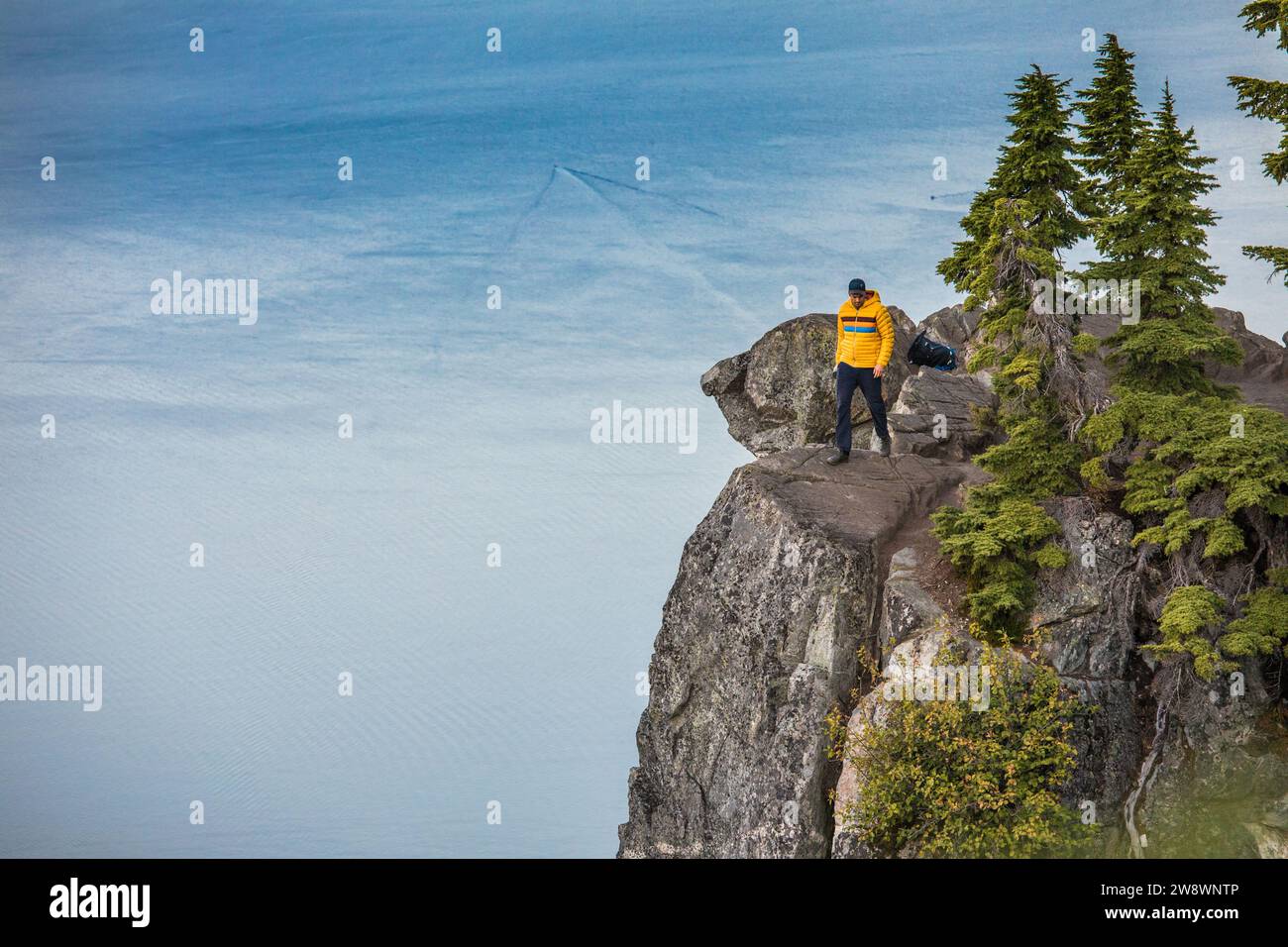 fit active man walks on rocky summit close to cliff edge Stock Photo ...
