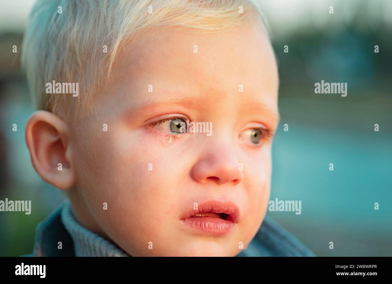 Little boy with tears close up defocused background. Emotional sad baby ...