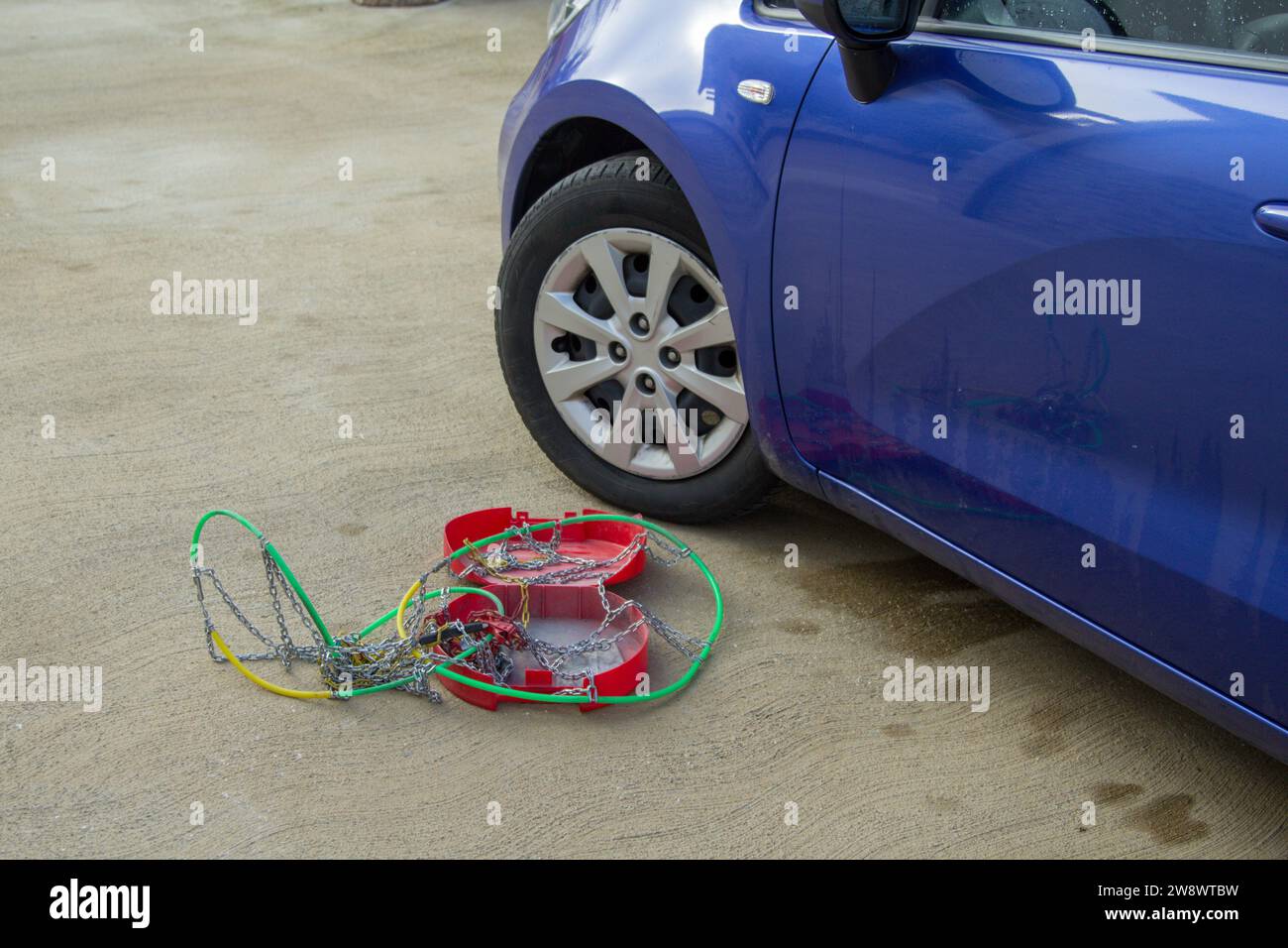 Image of a car with snow chains resting near the wheel. Difficulty in ...