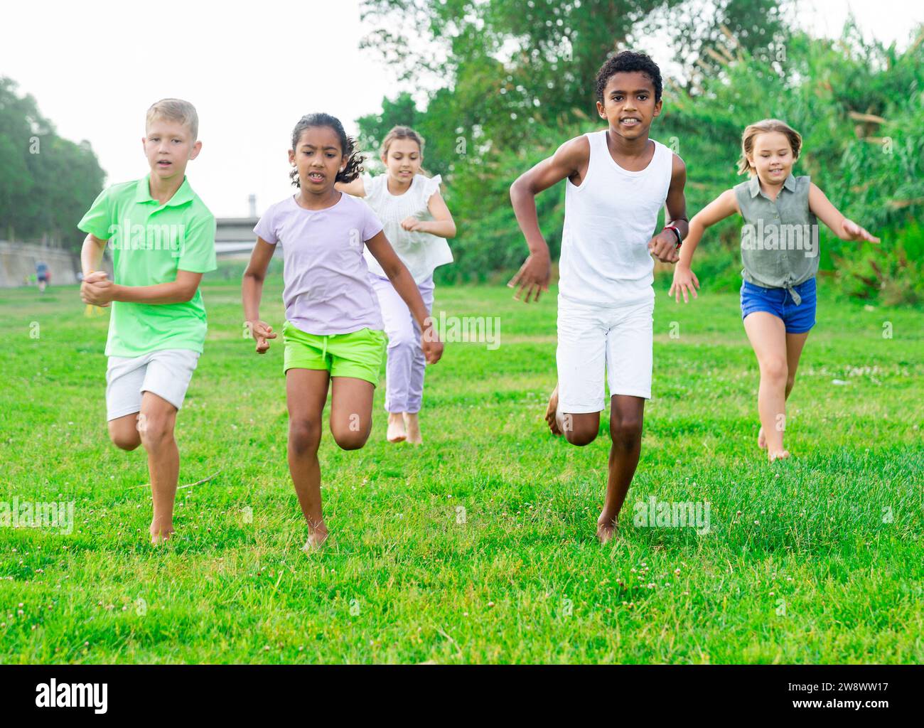 Children running on green grass Stock Photo - Alamy