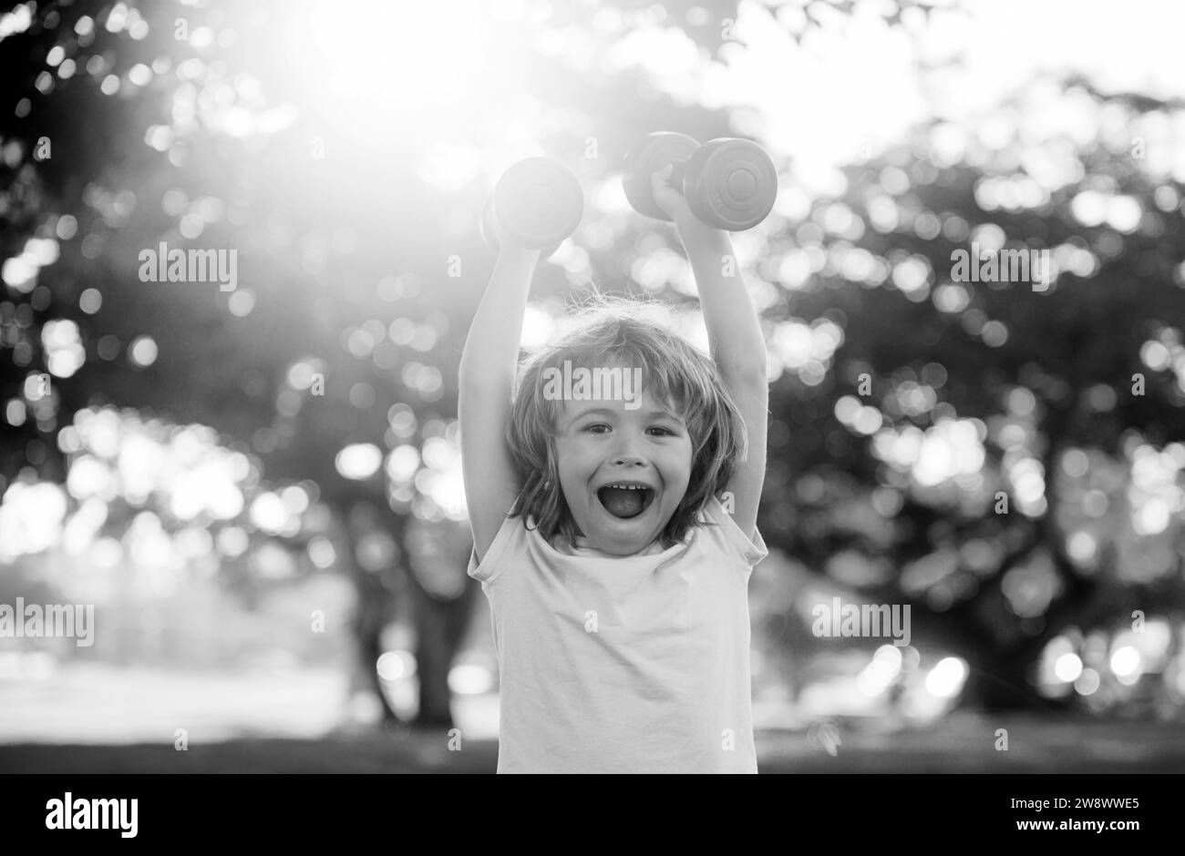 Fitness dumbbells, excited kid exercise workout outdoor. Amazed boy ...