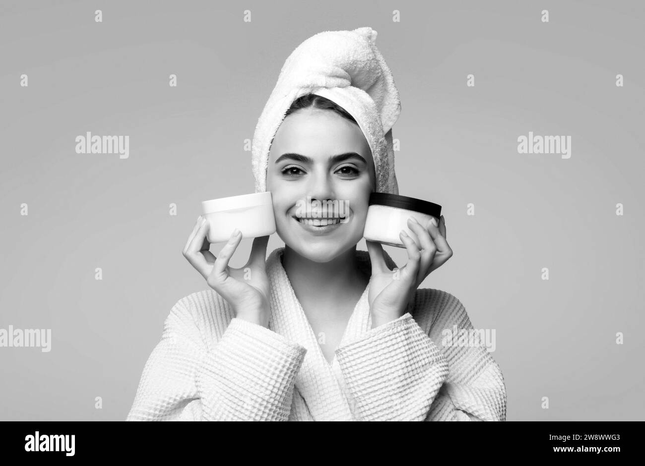 Beautiful smiling girl with clean skin proposing a cosmetics product ...